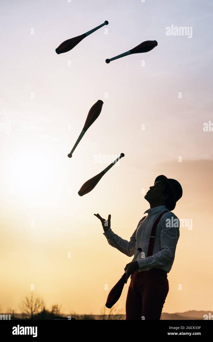 Low angle side view of unrecognizable male circus artist in hat ...
