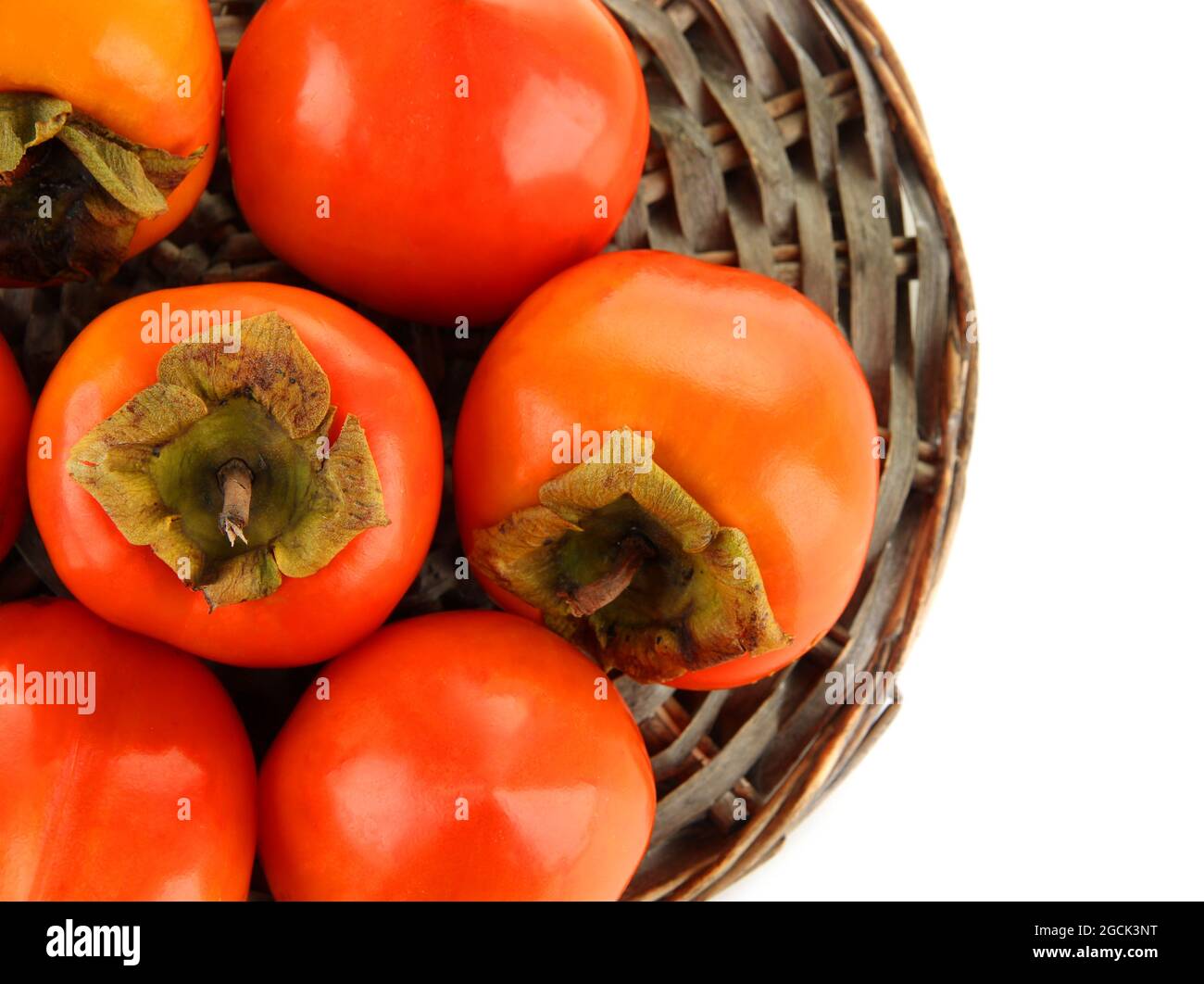 Ripe persimmons on wicker stand isolated on white Stock Photo - Alamy