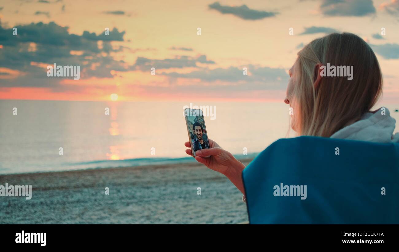 Young woman making video call to her friend with smartphone on the ...