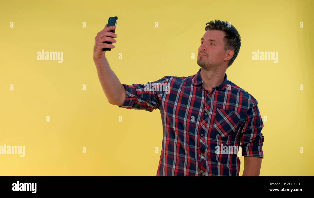 Attractive tall boy making selfie on smartphone. He smiling and ...