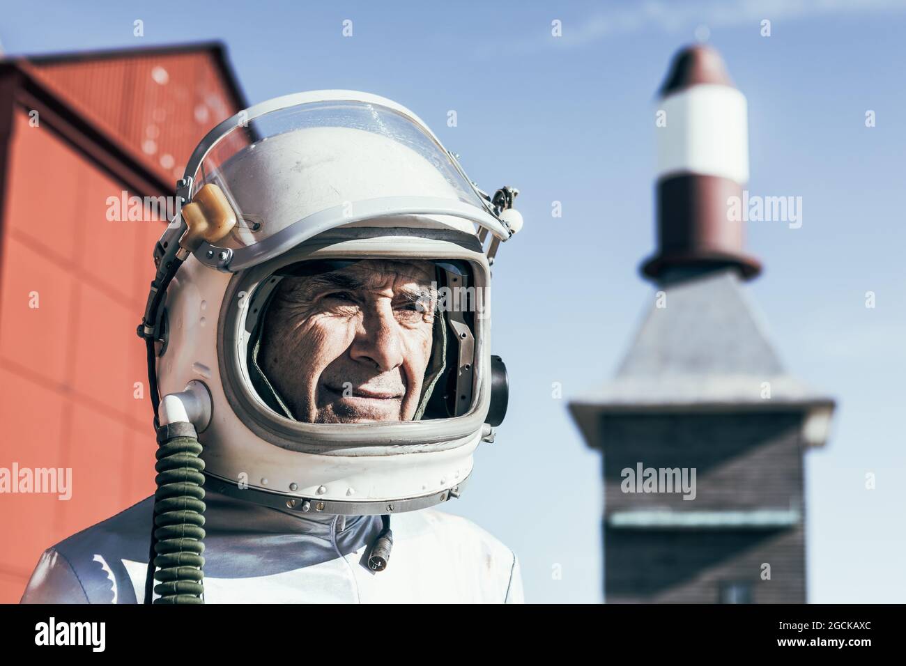Full body man in spacesuit standing on rocky ground against striped ...