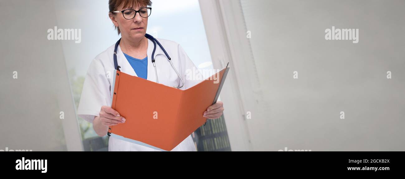 Female doctor holding a file in medical office Stock Photo - Alamy