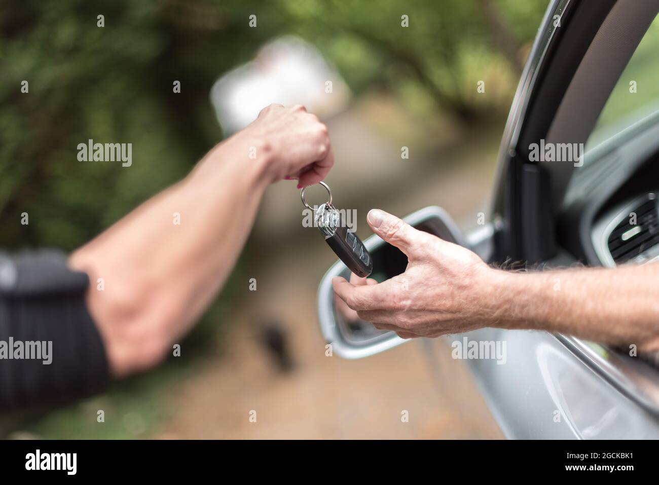 Woman handing another person automobile keys Stock Photo - Alamy
