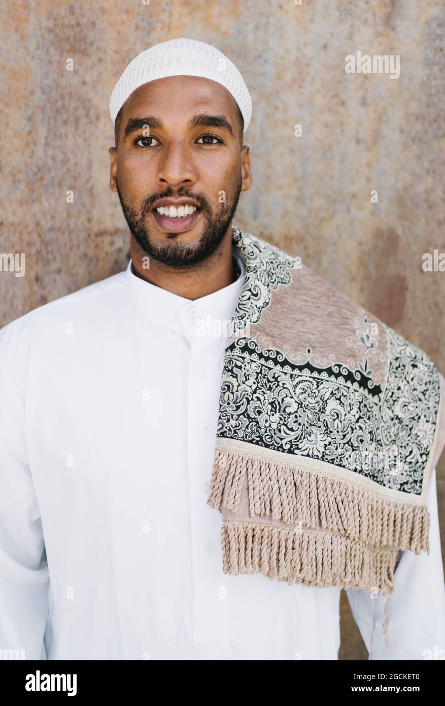 Islamic male in authentic white clothes while standing against grungy ...