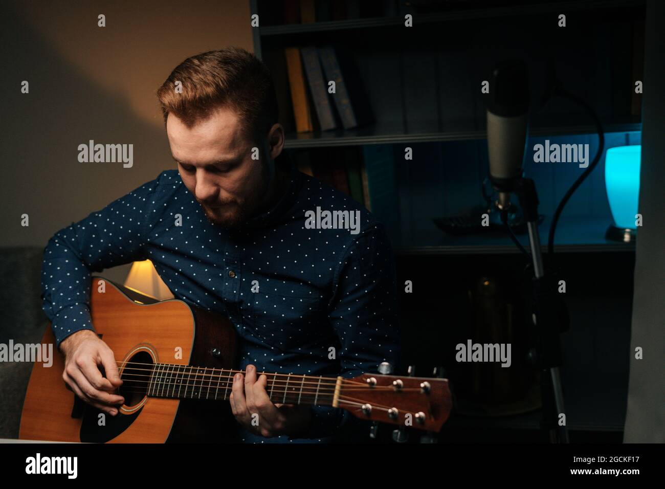 Portrait of guitarist singer man play on acoustic guitar recording sing ...
