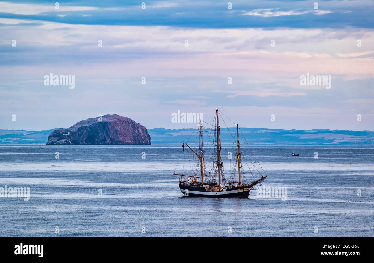 Pelican tall ship anchored by Bass Rock island at dawn, Firth of Forth ...