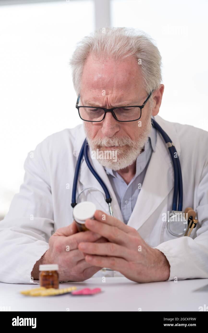 Portrait of senior doctor checking medicine Stock Photo - Alamy
