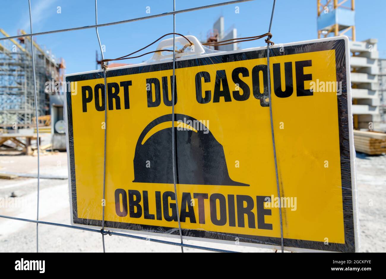 Mandatory helmet sign on construction site Stock Photo - Alamy