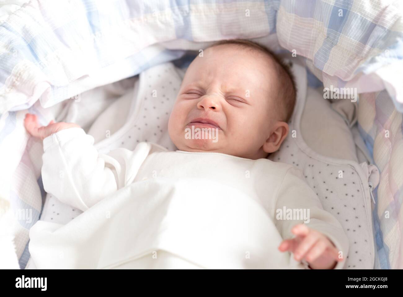 Little baby girl crying in her crib Stock Photo - Alamy