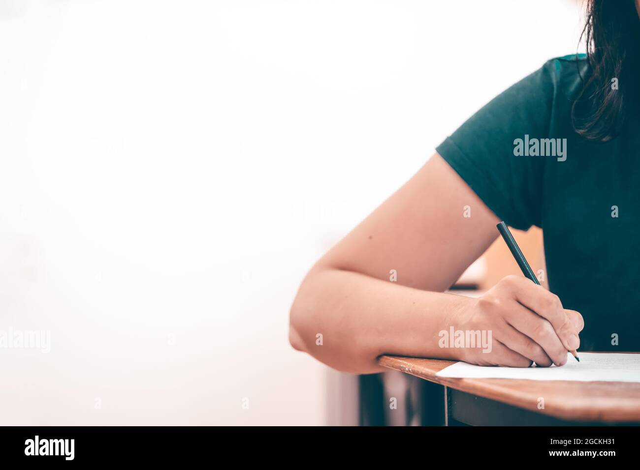 High school or university student holding pencil writing on paper ...