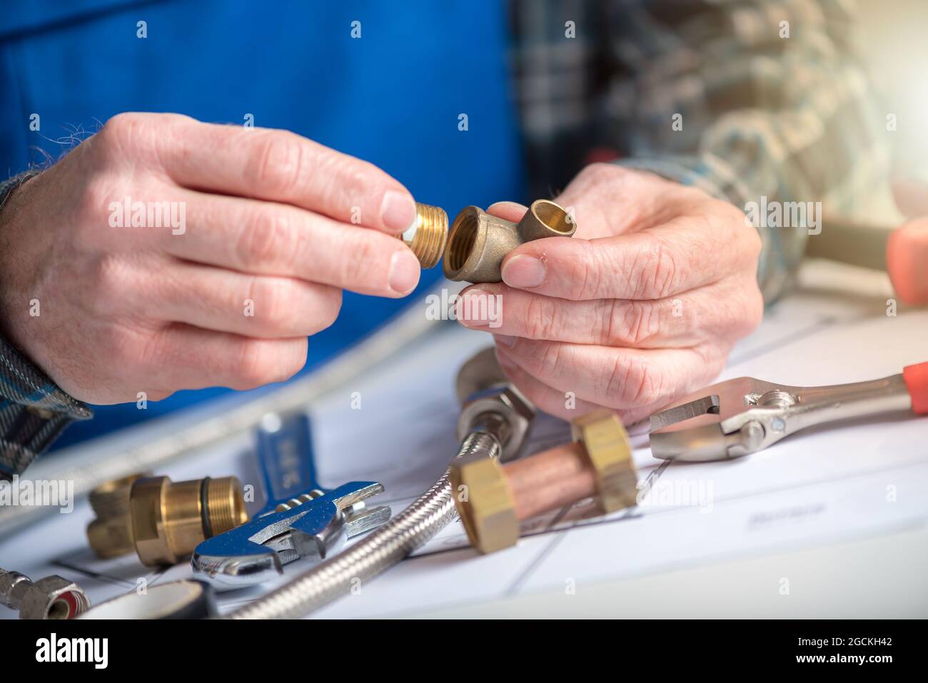 Plumber hands using plumbing fittings, light effect Stock Photo - Alamy