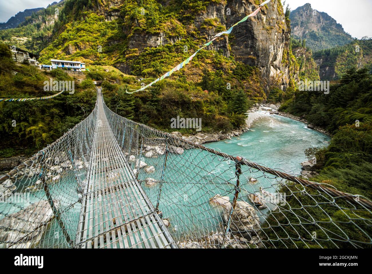 Metal suspension bridge crossing blue river in Himalayas mountains on ...