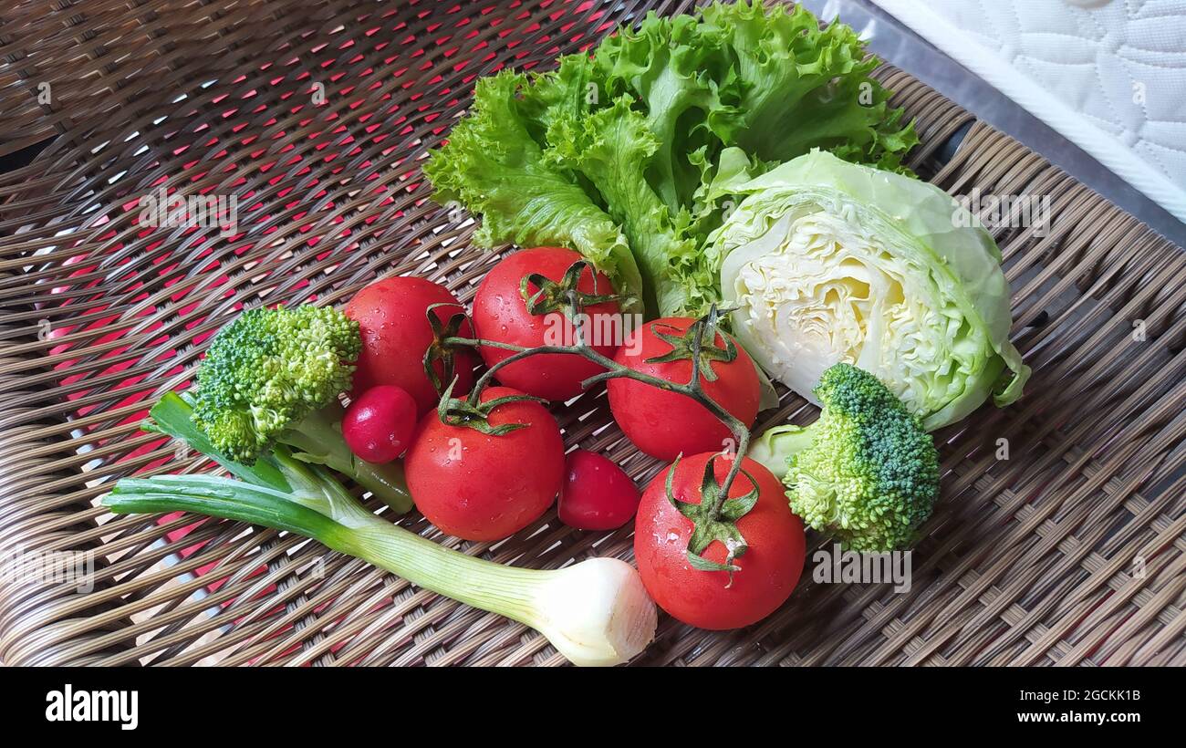 Raw vegetables on a wicker surface, cherry tomatoes, cabbage, leafy ...