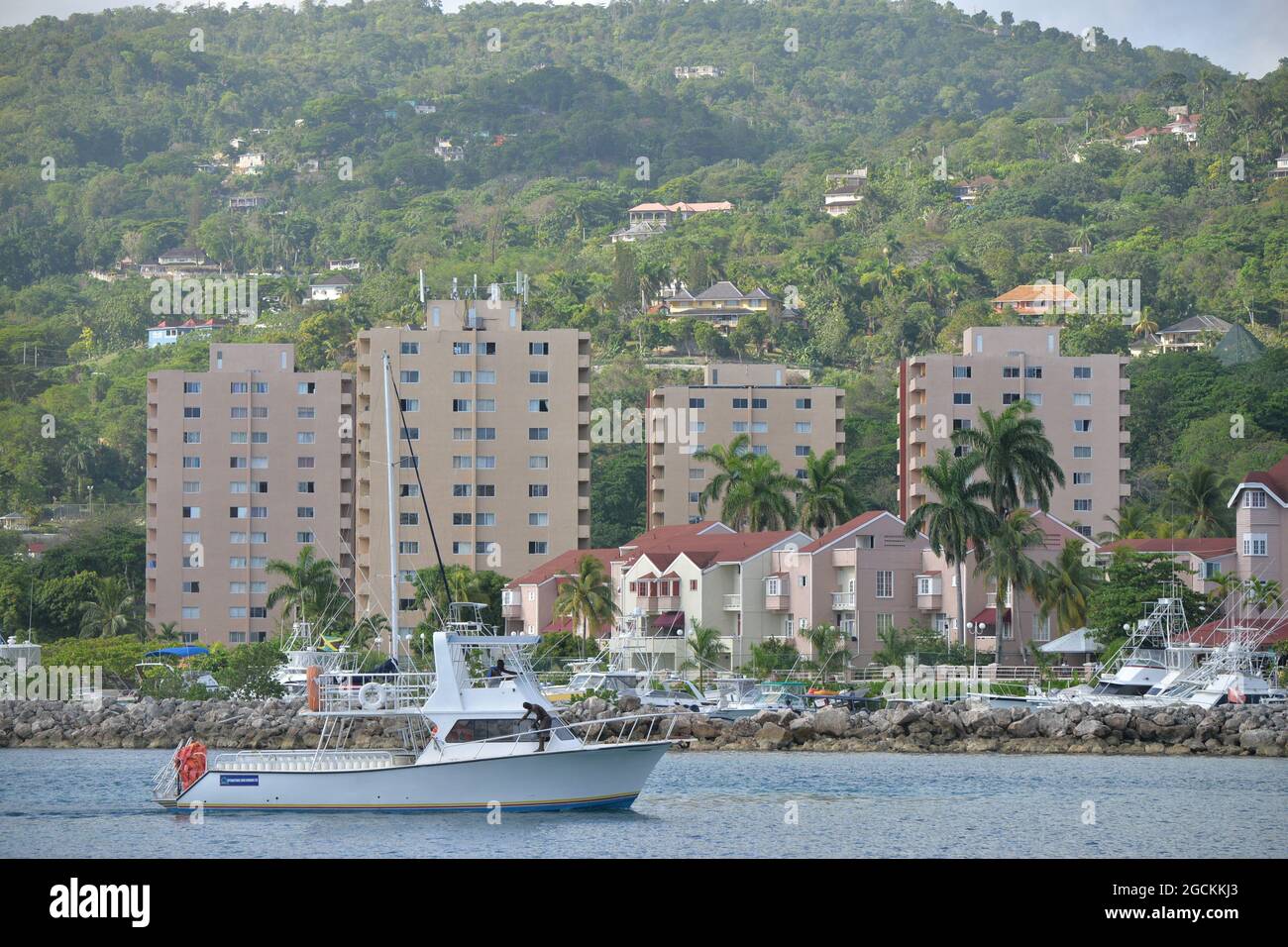 OCHO RIOS, JAMAICA - Jun 11, 2019: A boat in Jamaican sea with condo ...