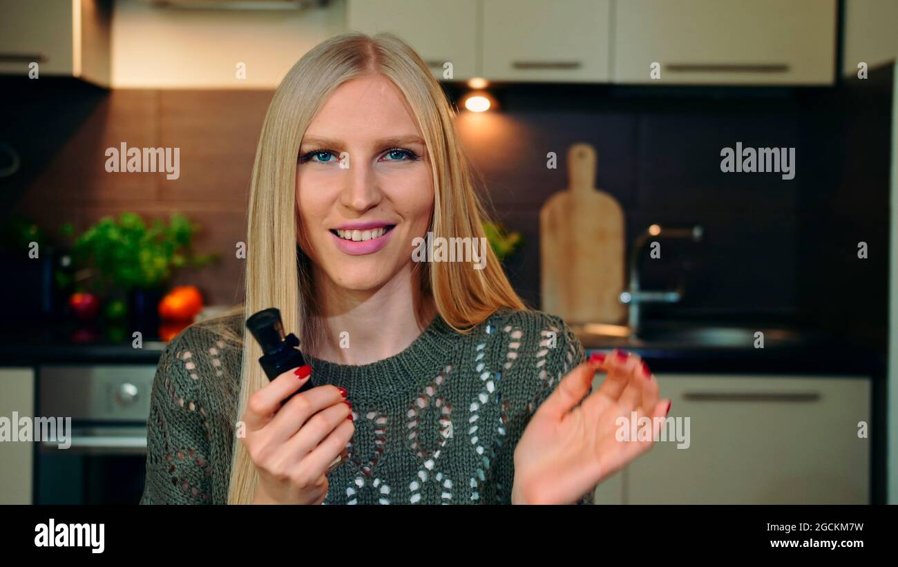 Young vlogger smelling perfume. Beautiful young woman spraying and ...