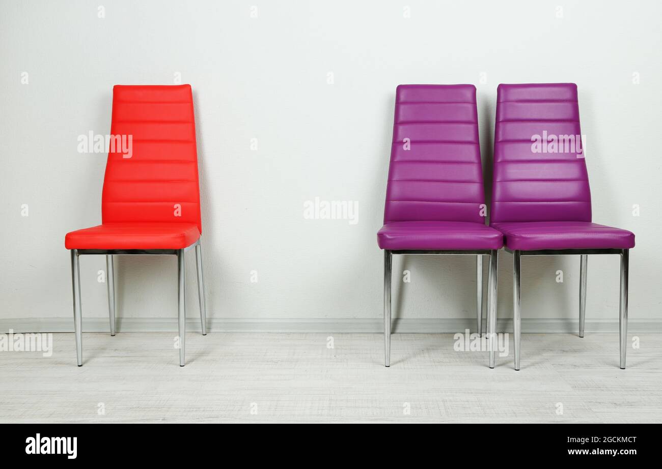 Modern color chairs on wall background Stock Photo - Alamy