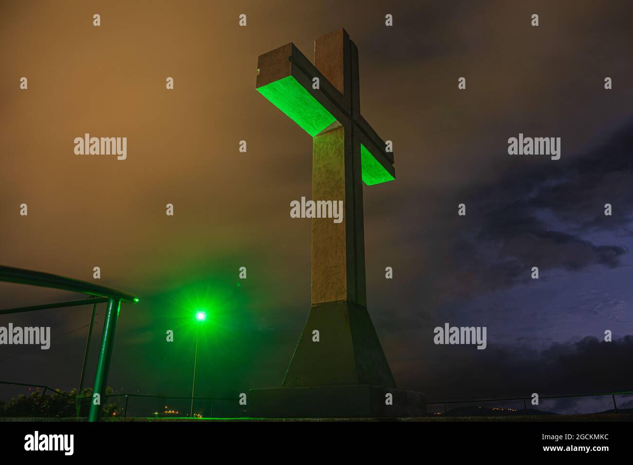 From below monument of a cross with background of clouds in the dark ...
