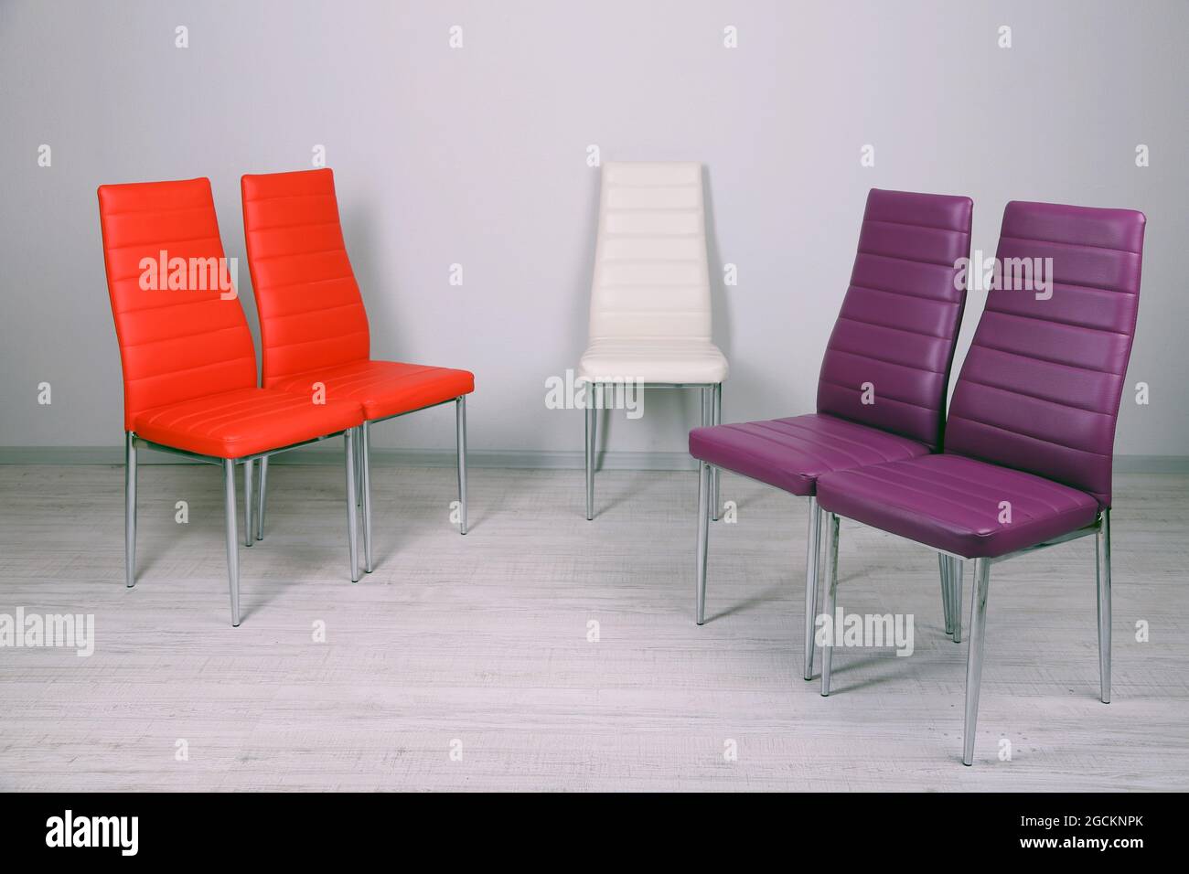 Modern color chairs on wall background Stock Photo - Alamy