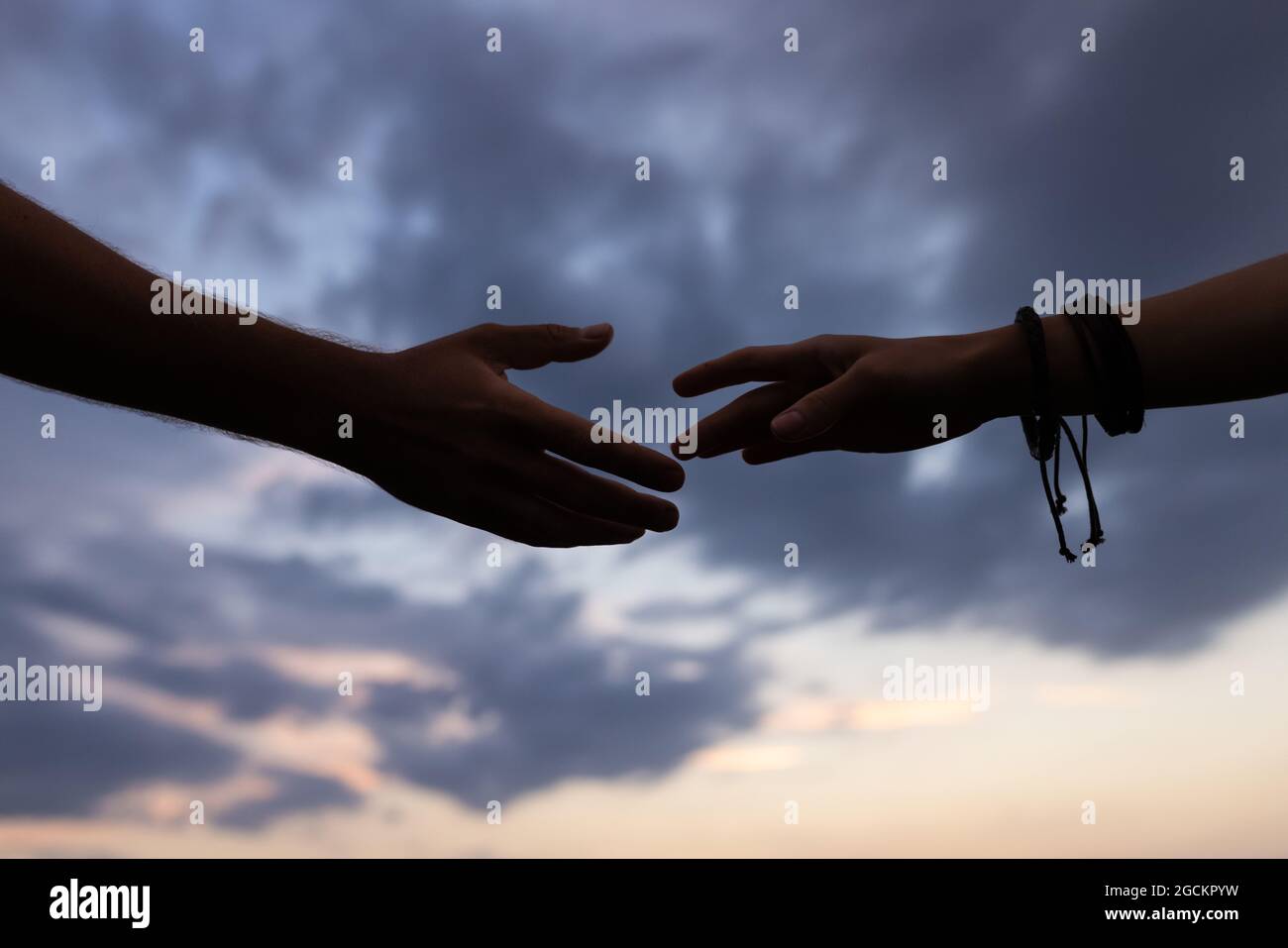 Silhouettes of male and female hands holding each other with love ...