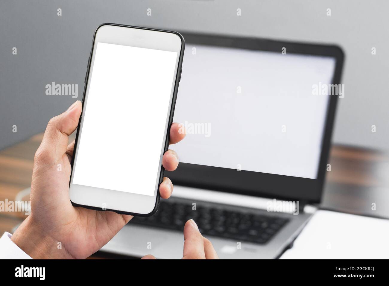 Closeup hand suing mobile smartphone in office work ,phone screen mock ...