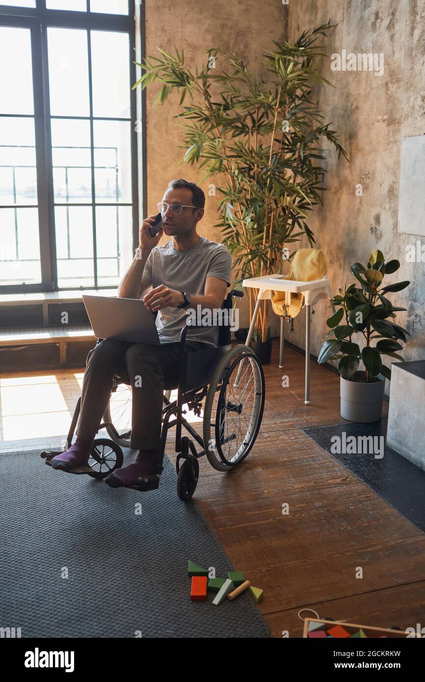 Vertical full length portrait of modern man with disability using ...