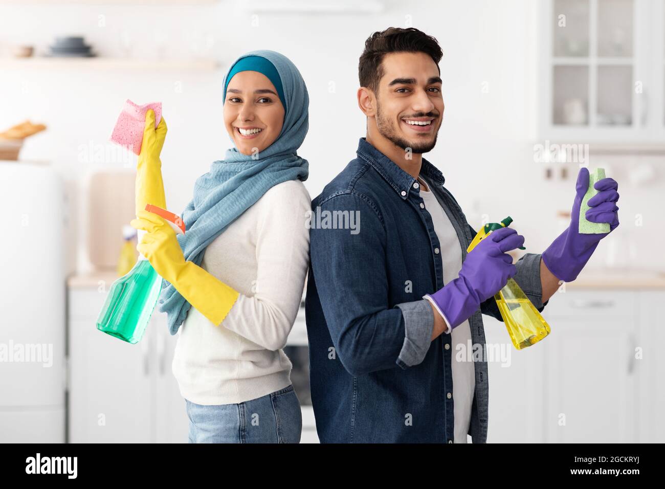 Cheerful middle-eastern husband and wife cleaning kitchen Stock Photo ...