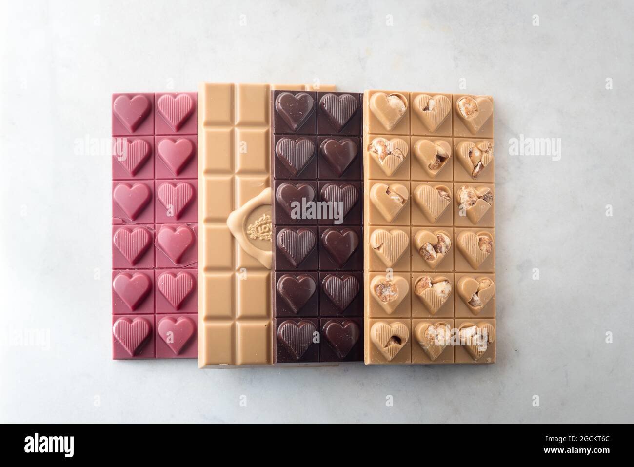 From above of delicious colorful chocolate bars placed in row on white ...