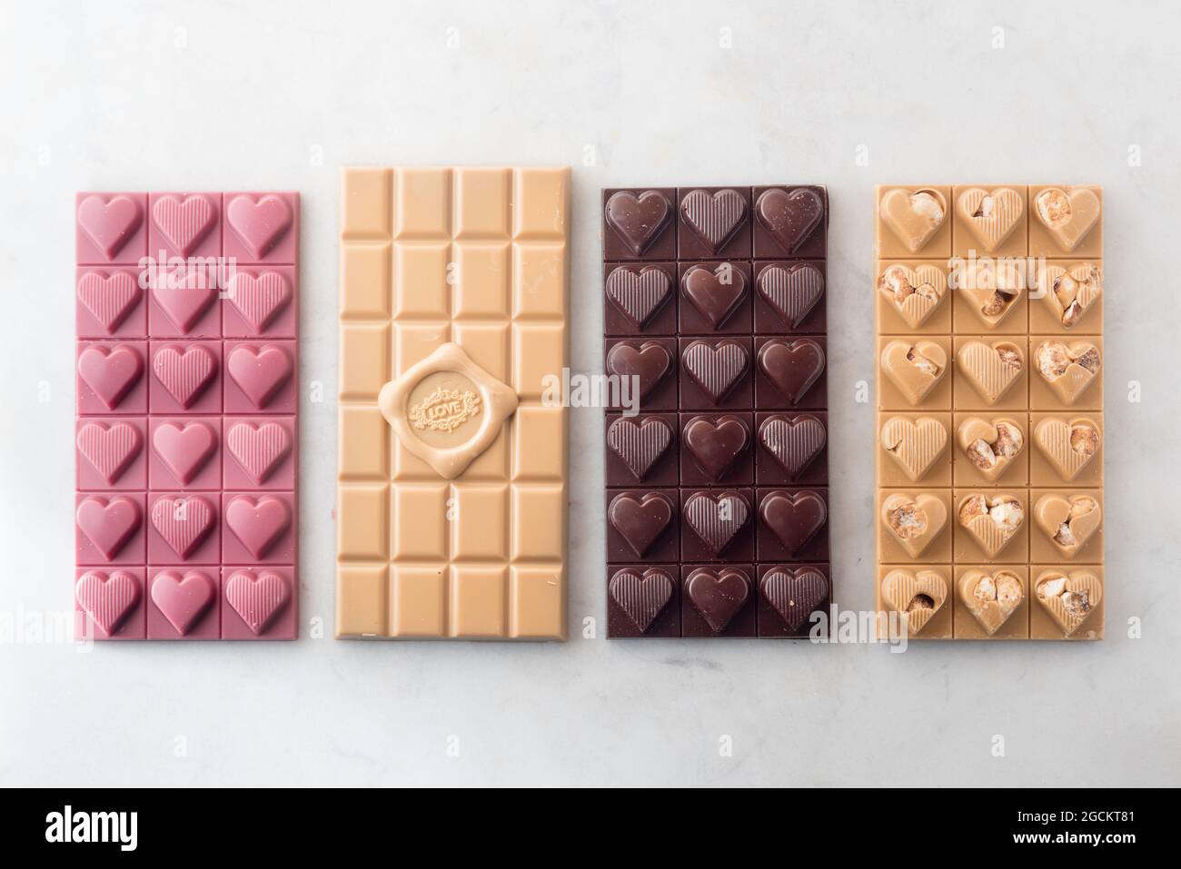 From above of delicious colorful chocolate bars placed in row on white ...