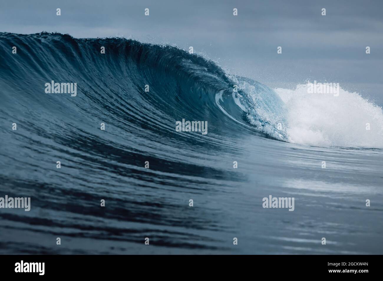 Perfect barrel wave on sandy beach. Breaking ocean wave with cloudy ...
