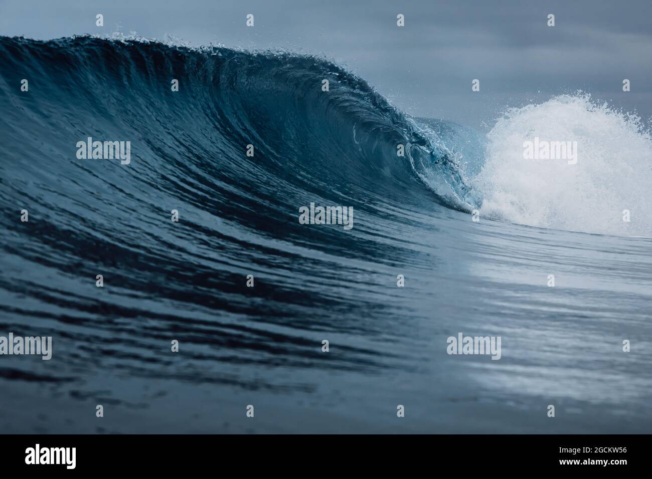 Perfect barrel wave on sandy beach. Breaking ocean wave with cloudy ...