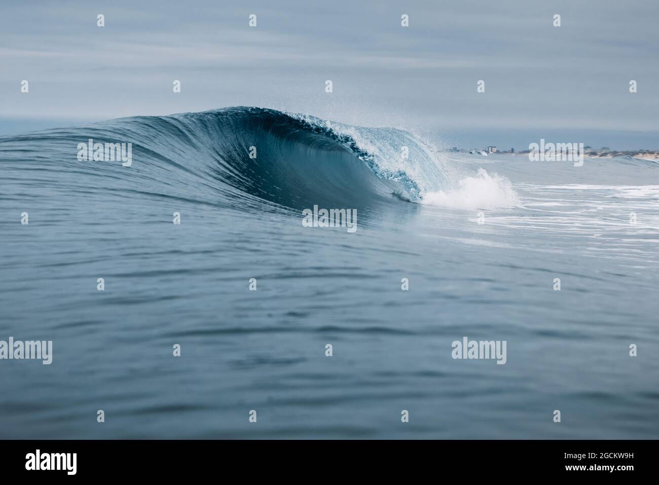Perfect barrel wave on sandy beach. Breaking ocean wave with cloudy ...