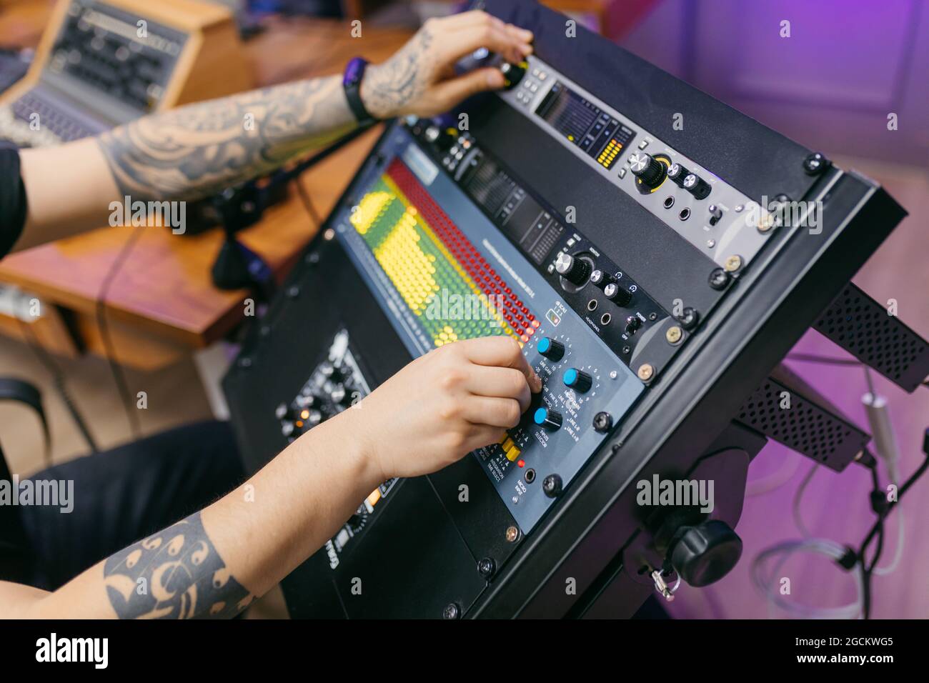 Side view of crop unrecognizable tattooed male sound engineer working ...