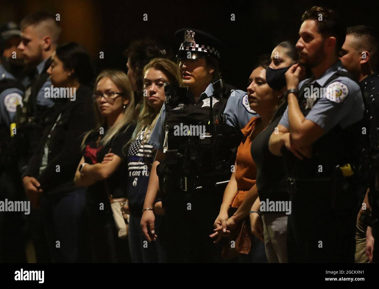 Chicago police officers watch the procession of police vehicles leading ...
