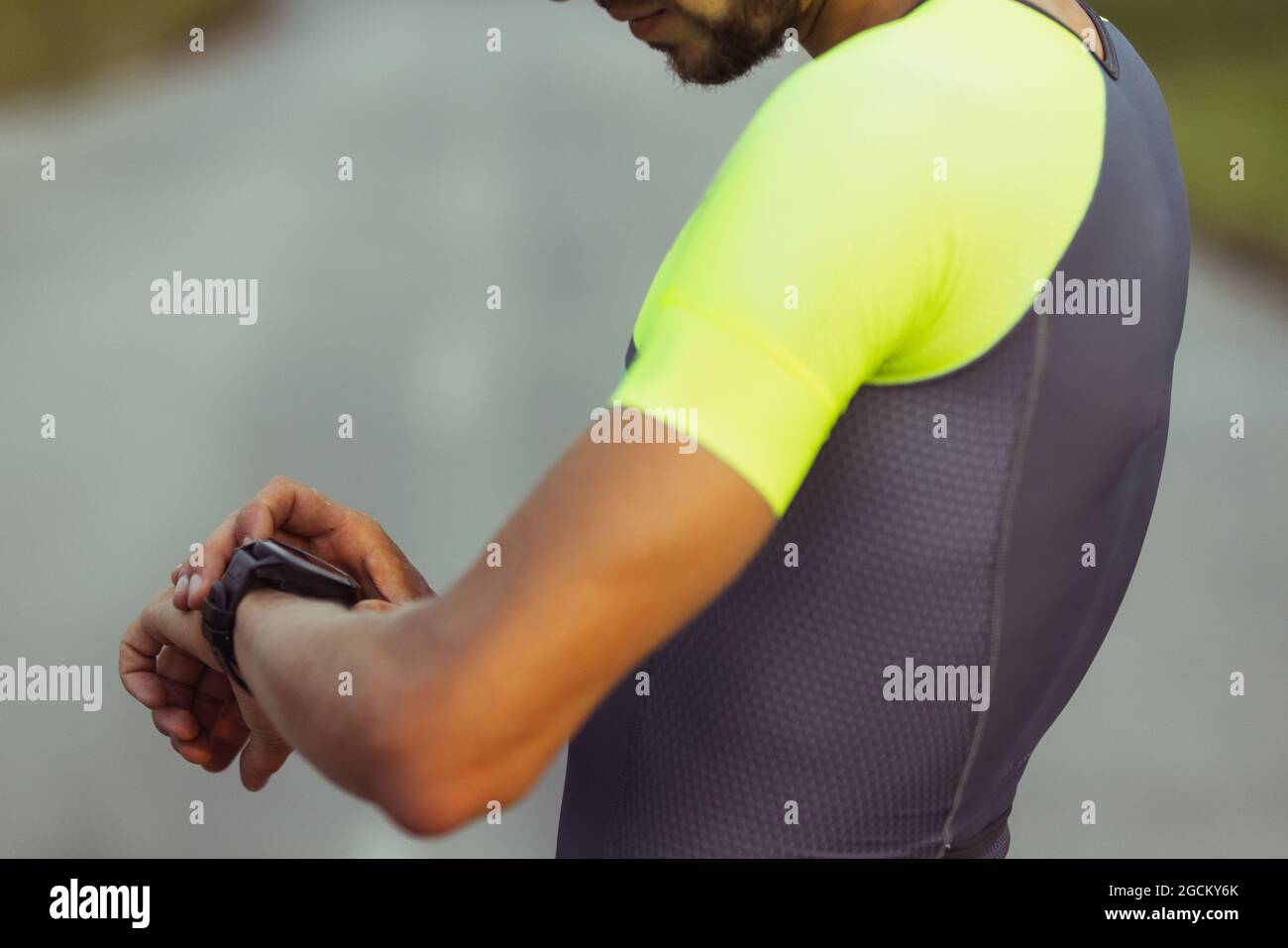 Young professional male triathlete, runner exercising outdoors on open ...