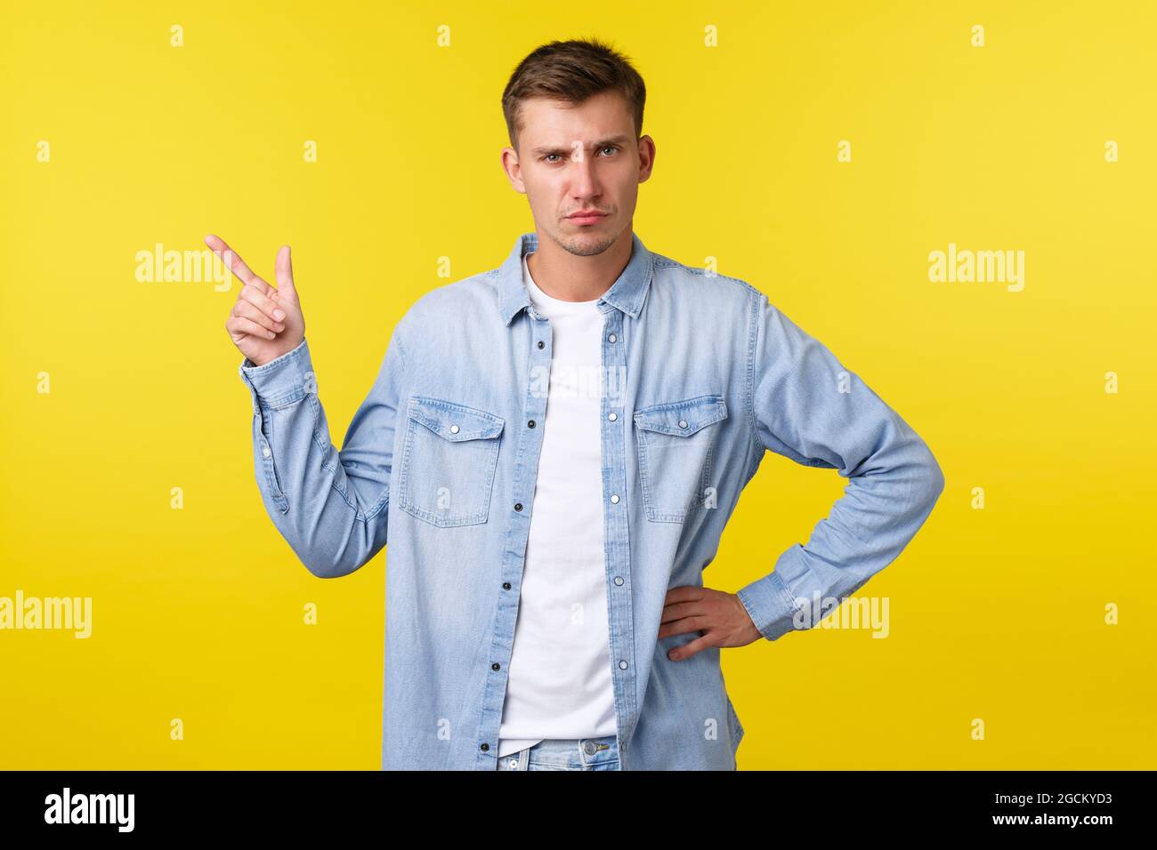 Serious-looking suspicious and blond handsome man frowning, pointing ...