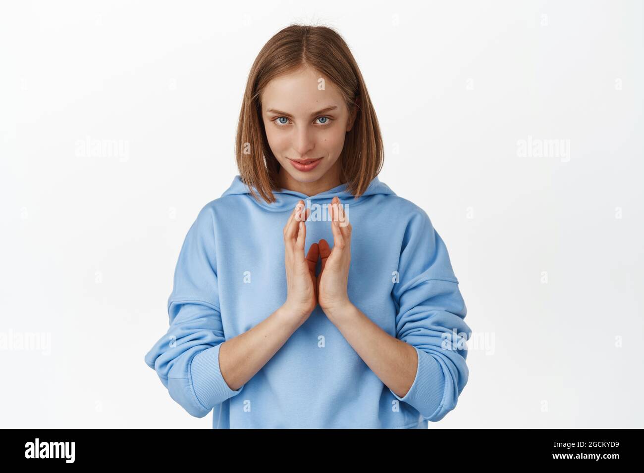 Image of cunning girl, smiling sly and steeple fingers like evil genius ...