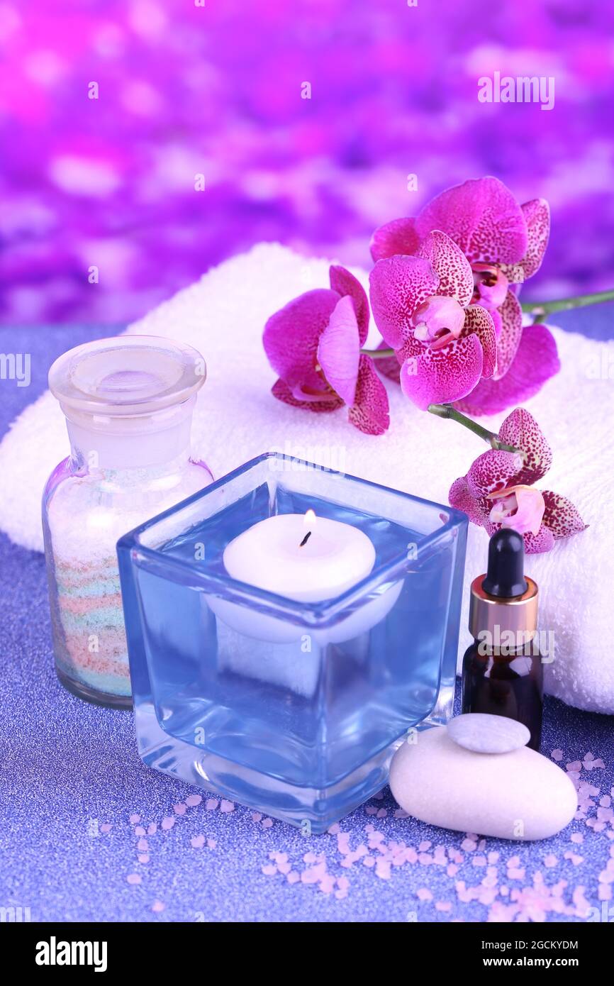 Beautiful spa setting with orchid on purple background Stock Photo - Alamy