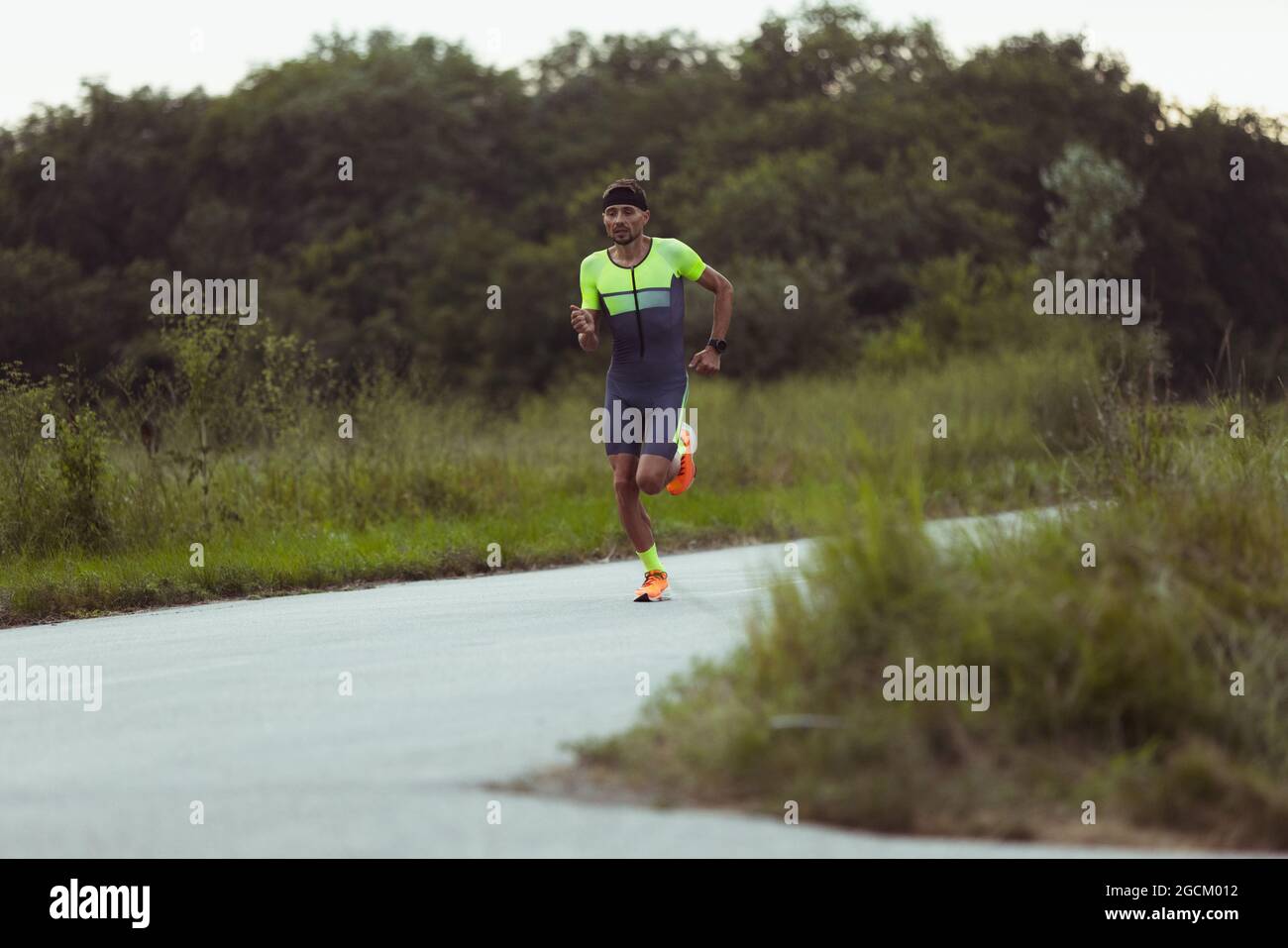 Image of young professional male triathlete, runner in motion on open ...