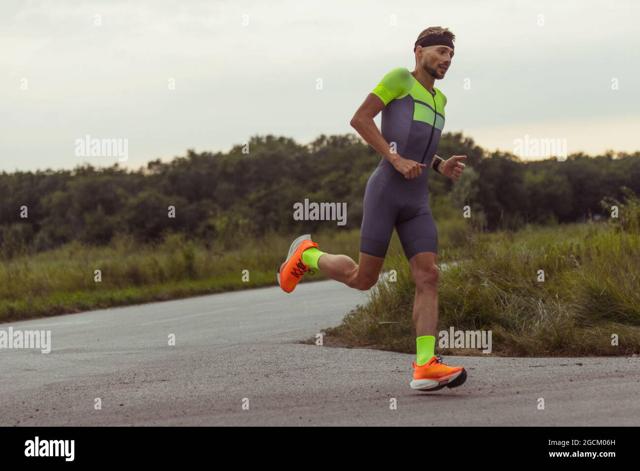Image of young professional male triathlete, runner in motion on open ...