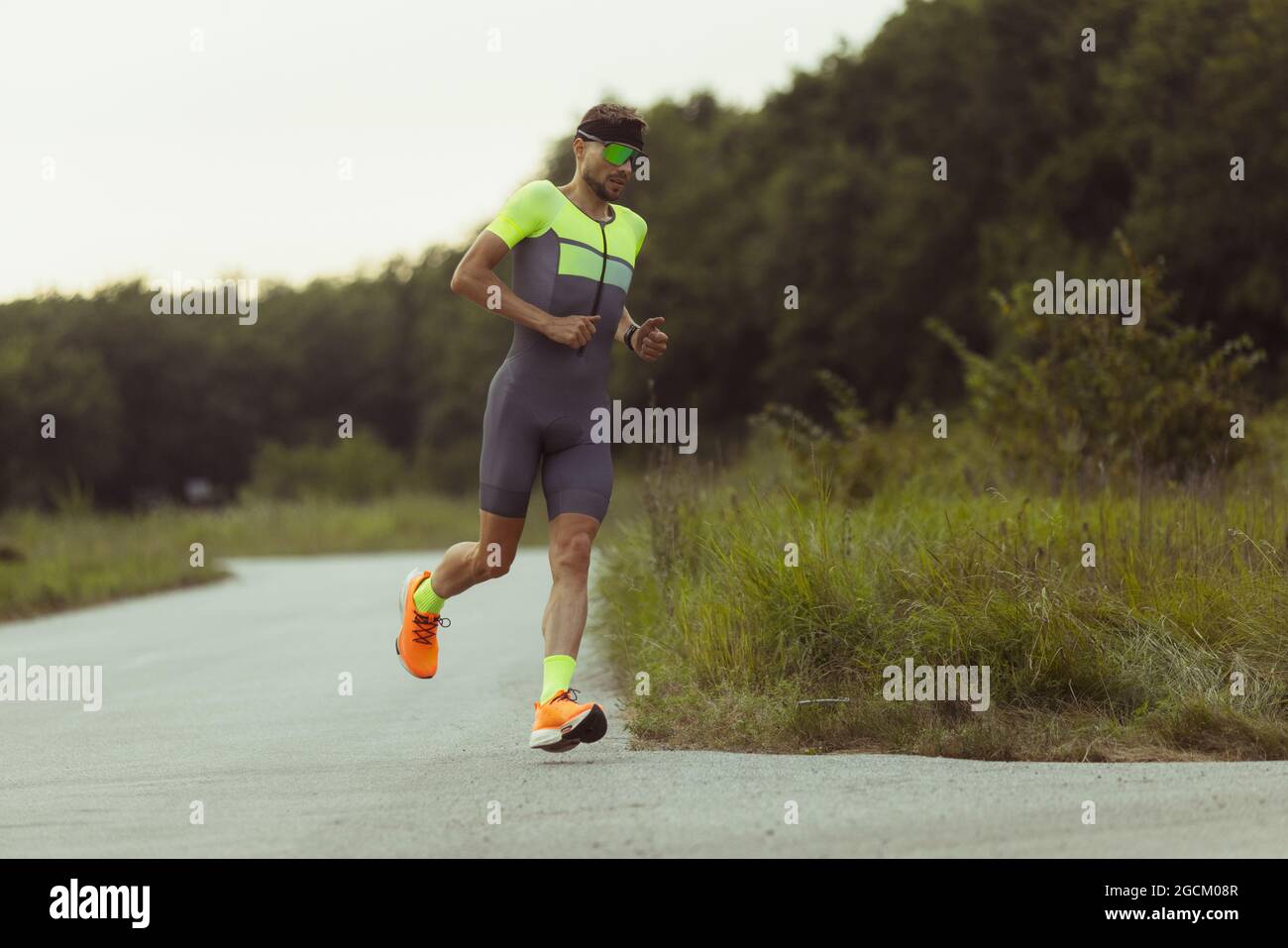Image of young professional male triathlete, runner in motion on open ...
