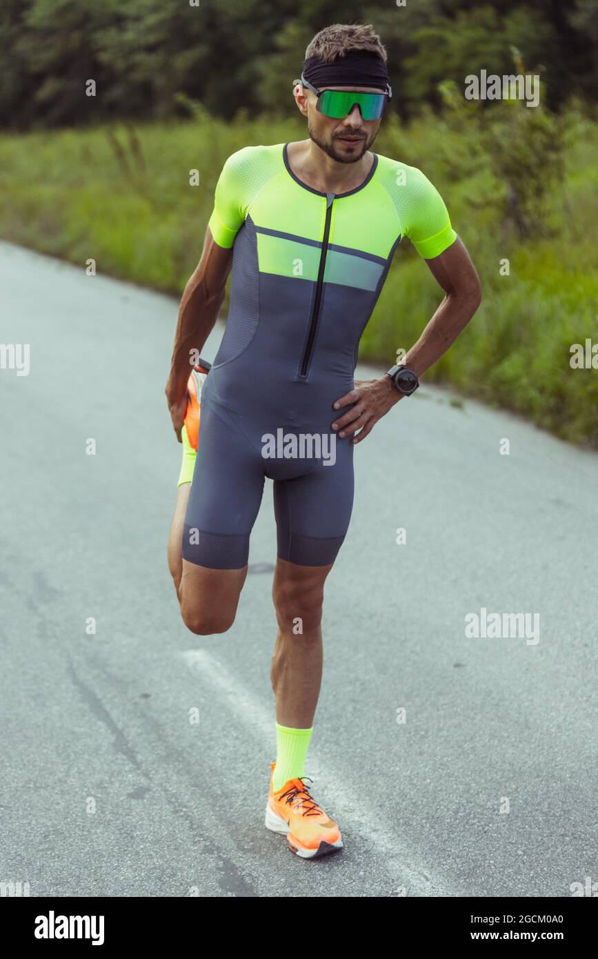 Image of young professional male triathlete, runner outdoors on open ...