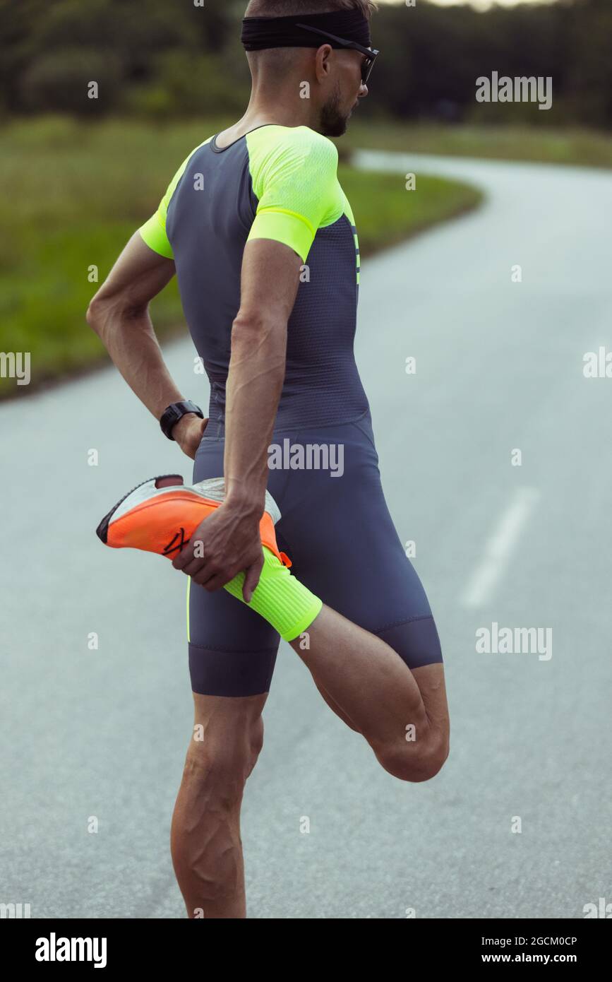 Image of young professional male triathlete, runner outdoors on open ...