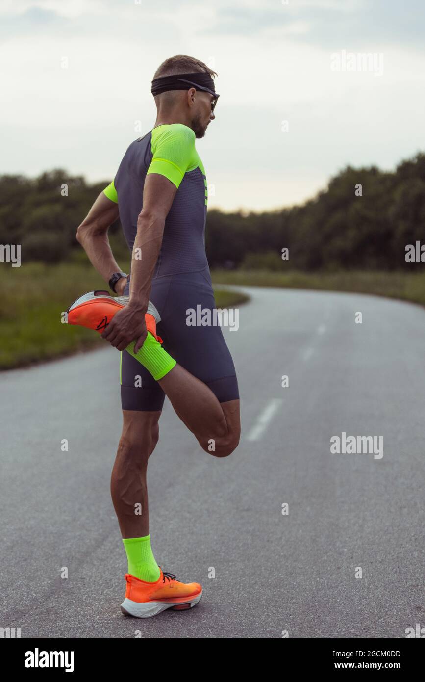 Image of young professional male triathlete, runner outdoors on open ...
