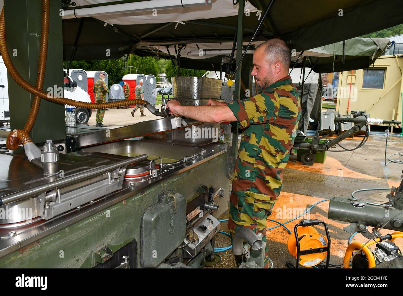 Illustration shows a cook preparing the evening meal at a mobile ...