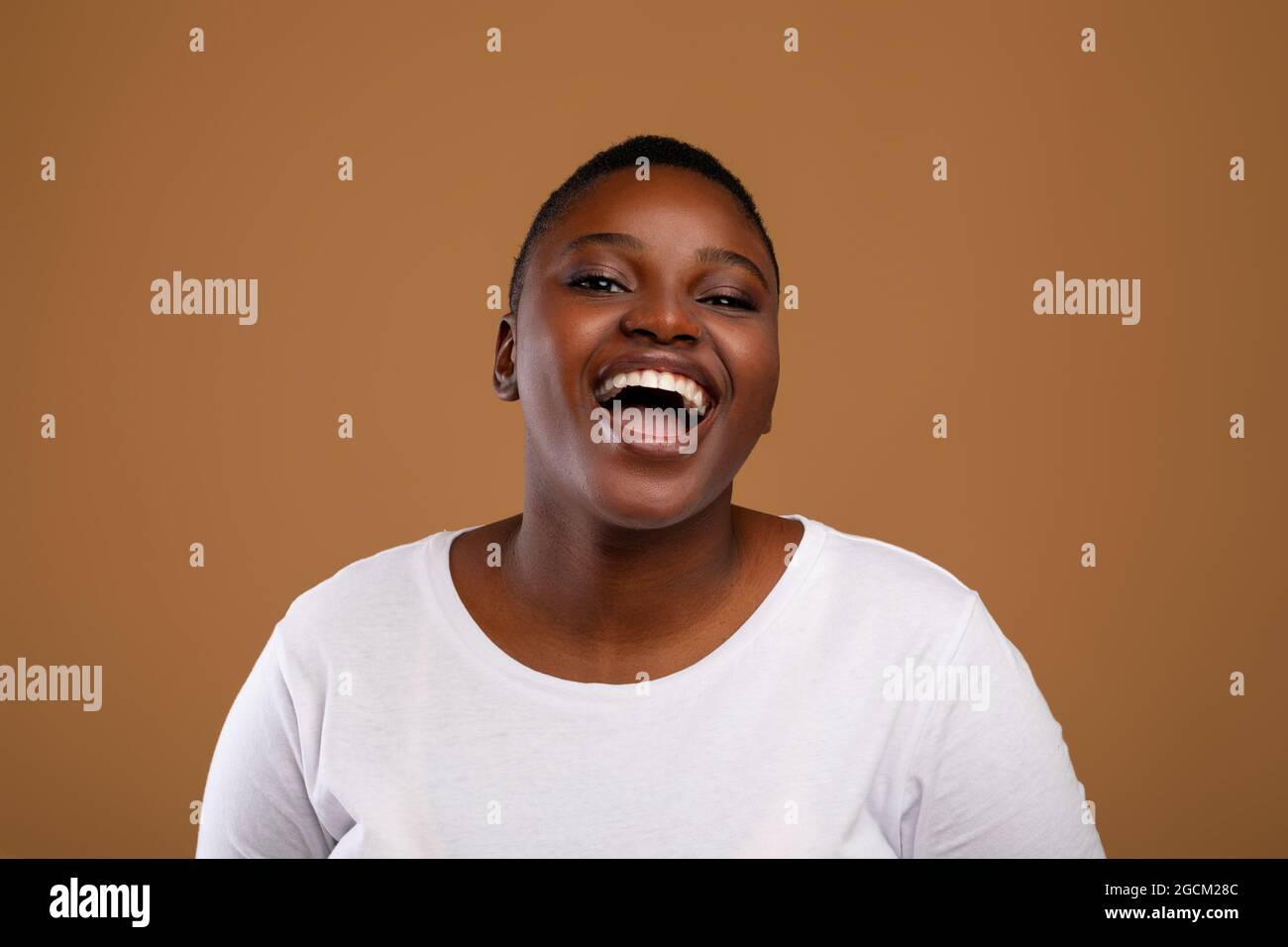 Portrait of casual young chubby black woman laughing Stock Photo - Alamy