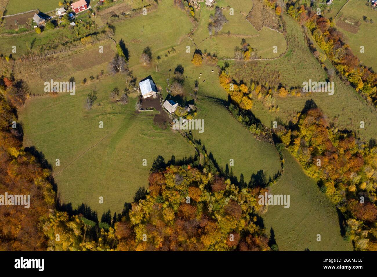 Aerial view of a small countryside homestead and colorful autumn forest ...