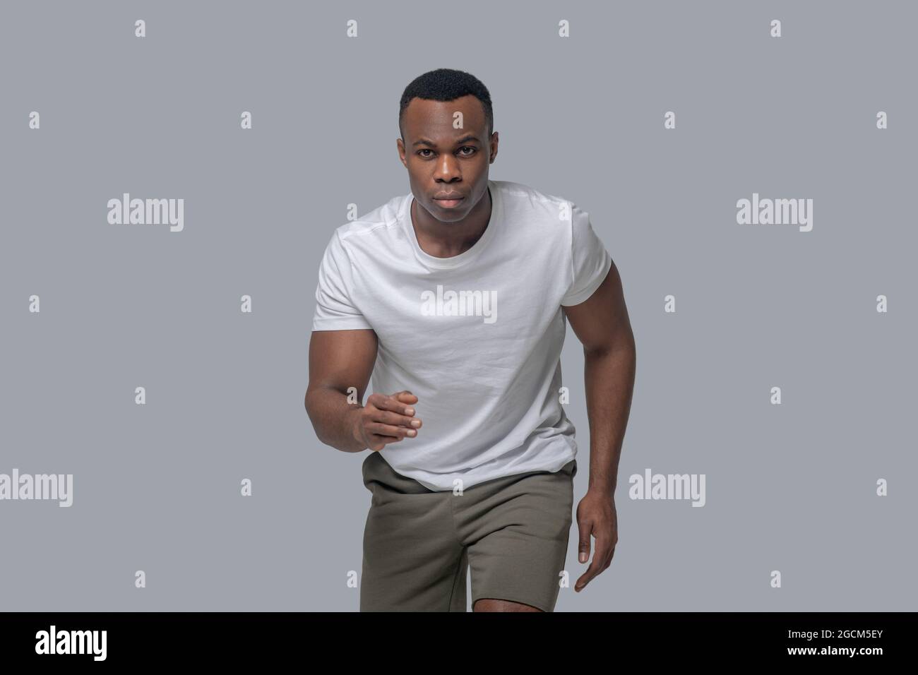 A dark-skinned young guy running and looking determined Stock Photo - Alamy