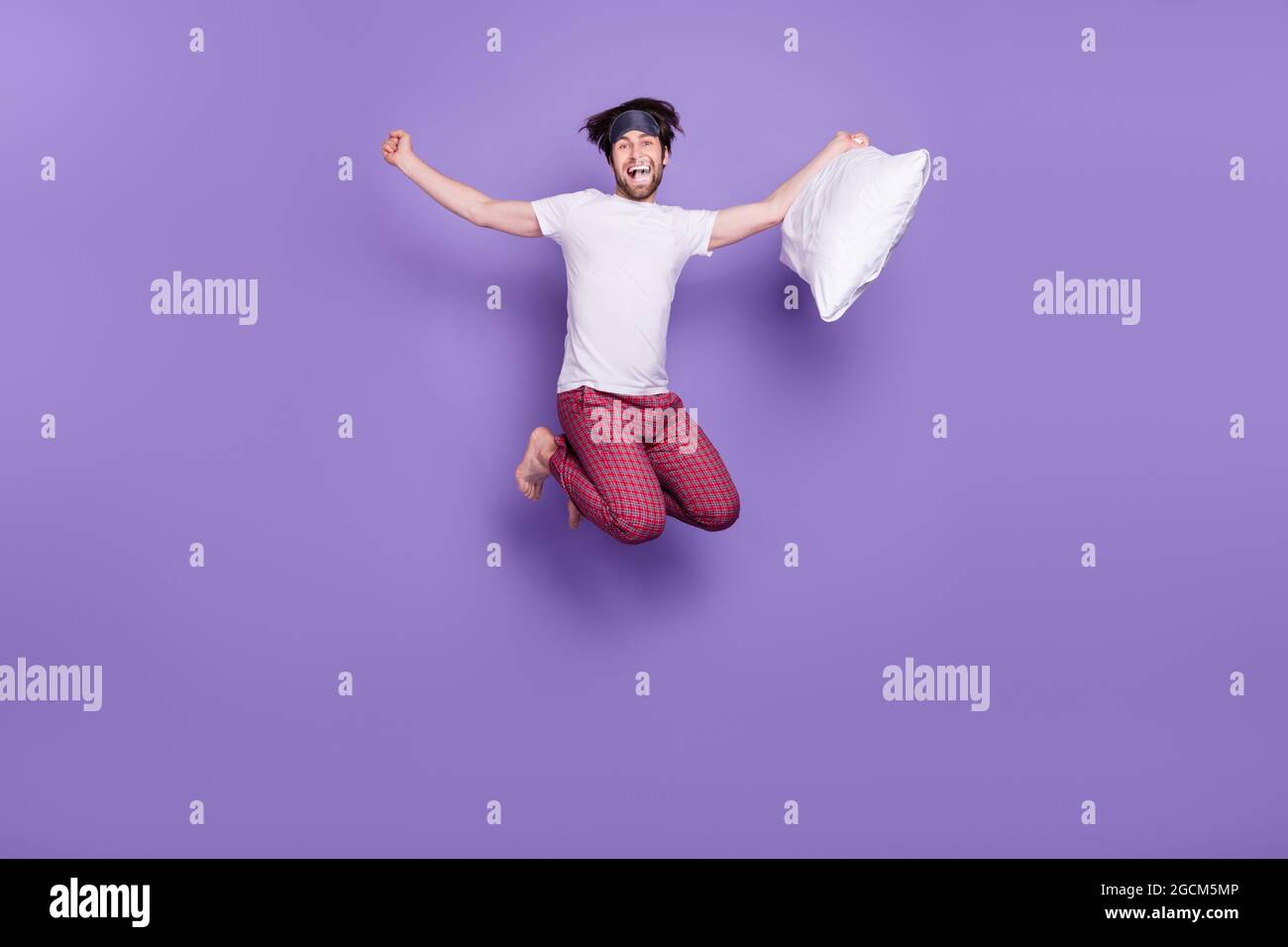 Full size photo of astonished excited handsome guy hold cushion raise ...
