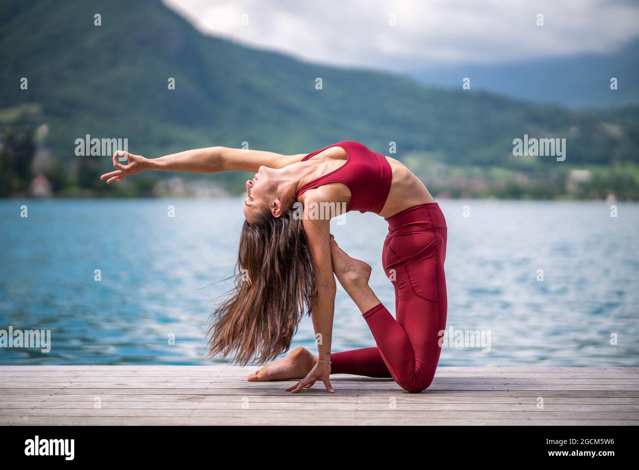 Side view of peaceful female practicing yoga in Ushtrasana and doing ...