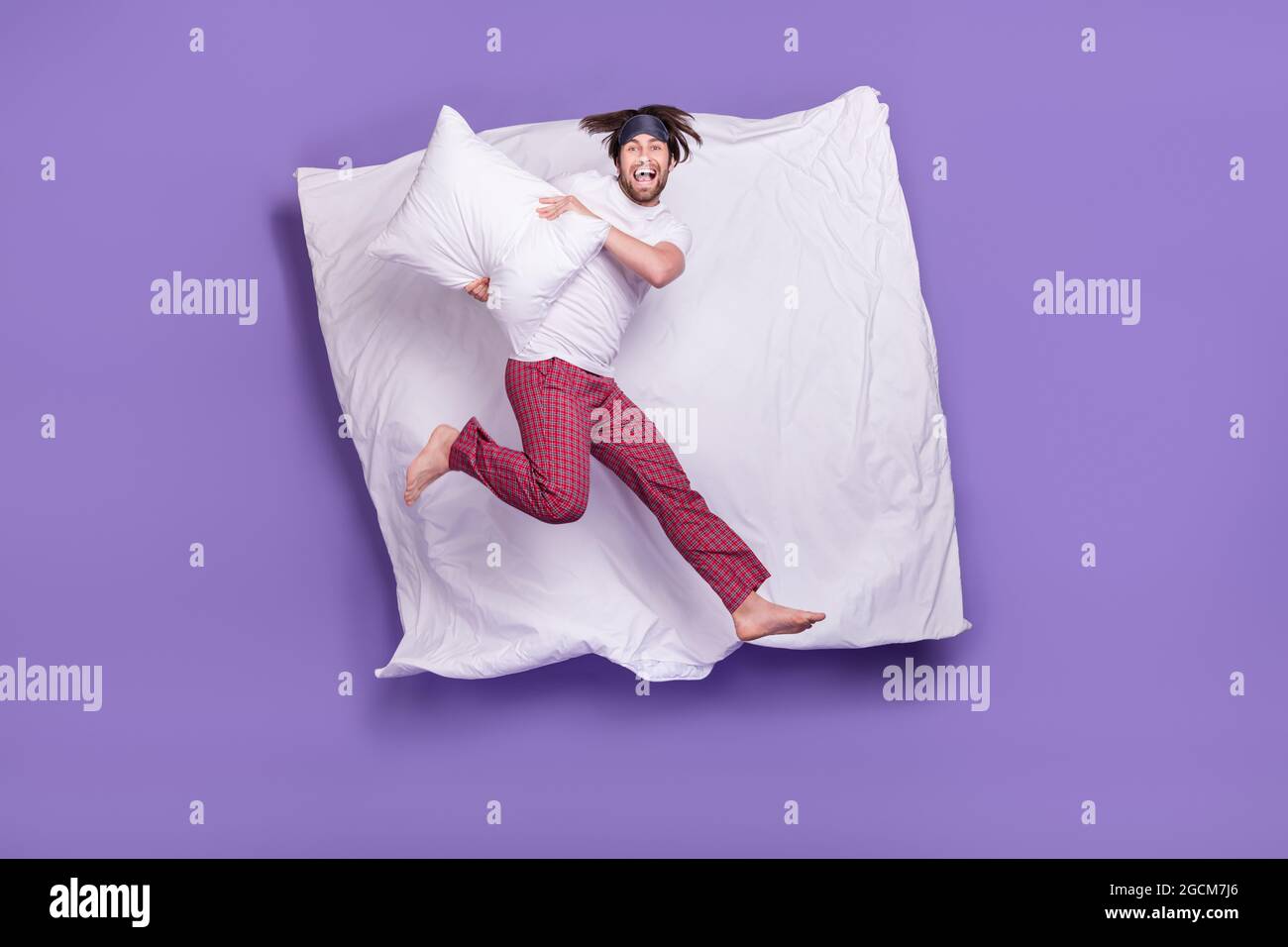 Full length photo of excited cheerful guy hold cushion have good mood ...